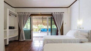 Quarto com cama, guarda-roupa e vista para uma área de estar ao ar livre.