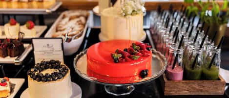 Buffet com diversos doces, incluindo bolos e tortas de fruta.