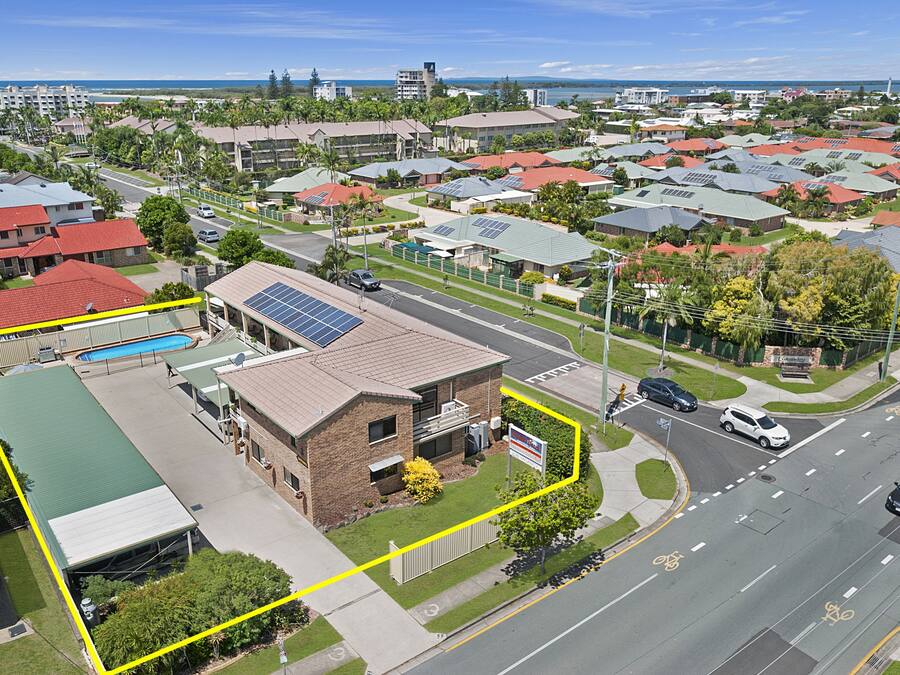 Área residencial com casas, piscina e uma rua com carros.