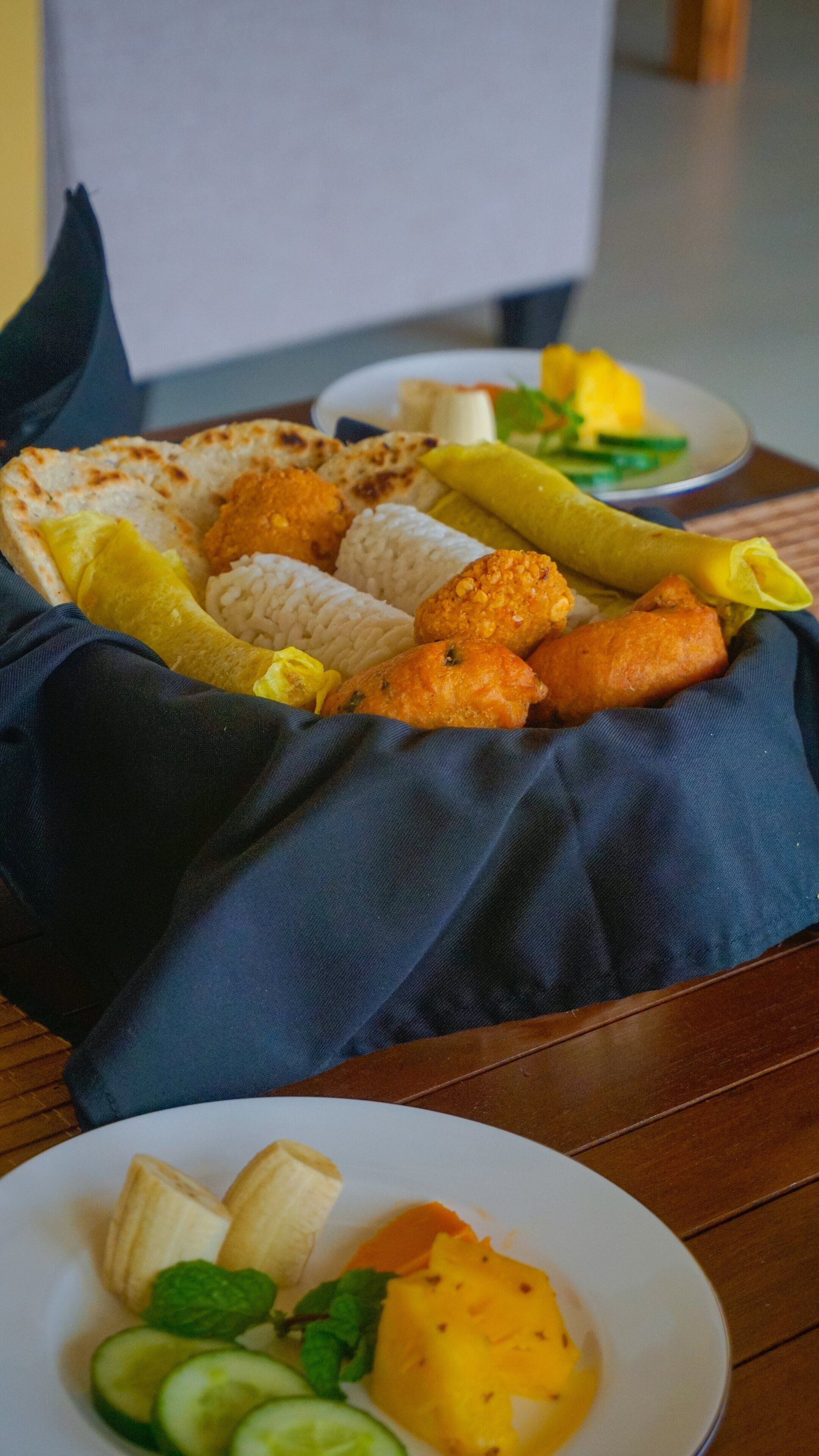 Uma mesa com um prato de comida que inclui pão, arroz e legumes.