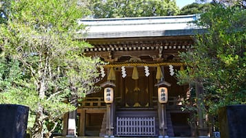 Edifício japonês tradicional com estrutura de madeira, cerca branca e decorações penduradas.