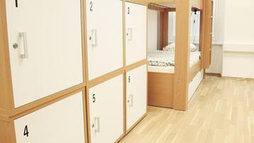 Quarto com beliches e armários individuais numerados.