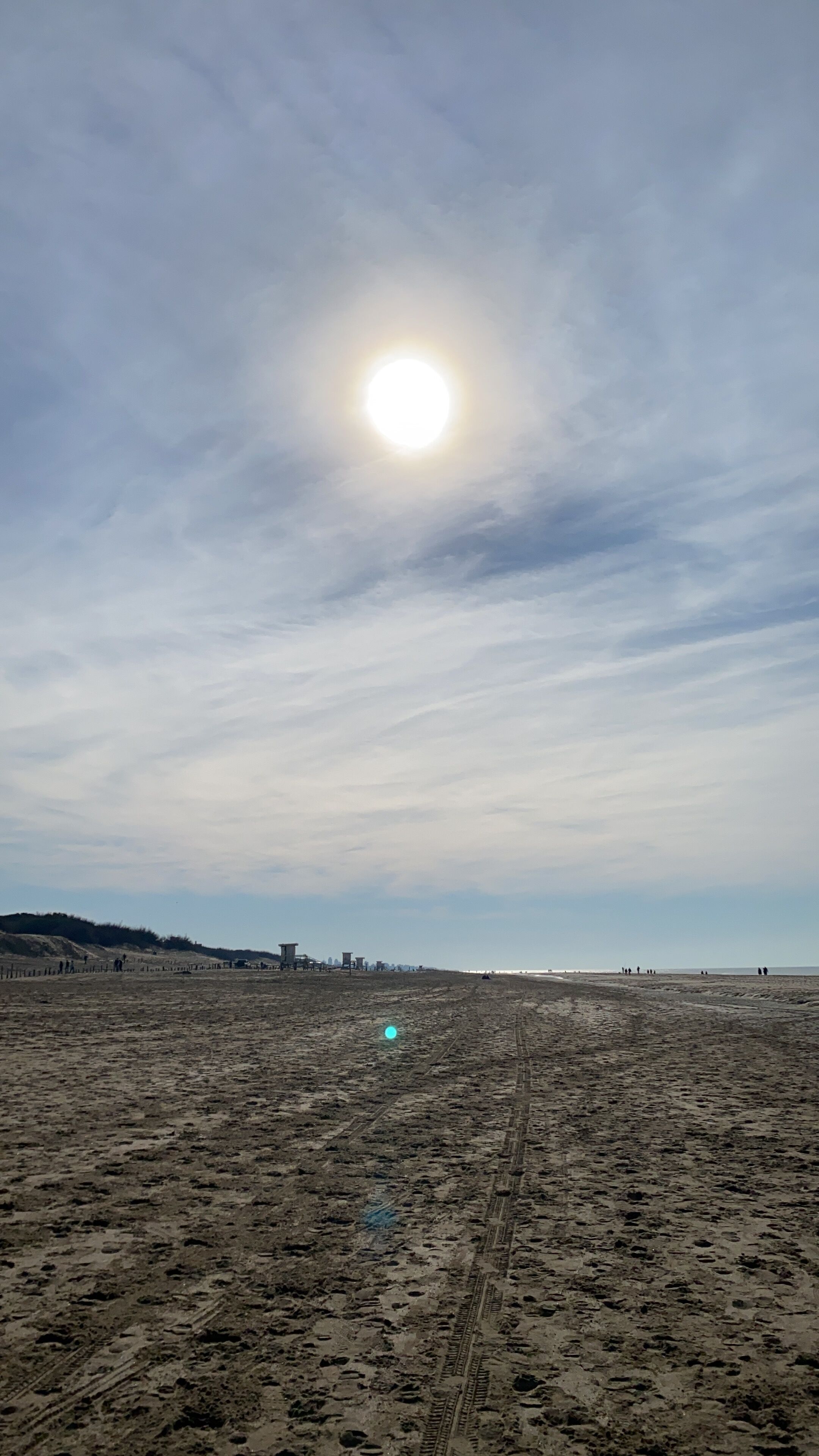 Uma praia com céu limpo e o sol brilhando.