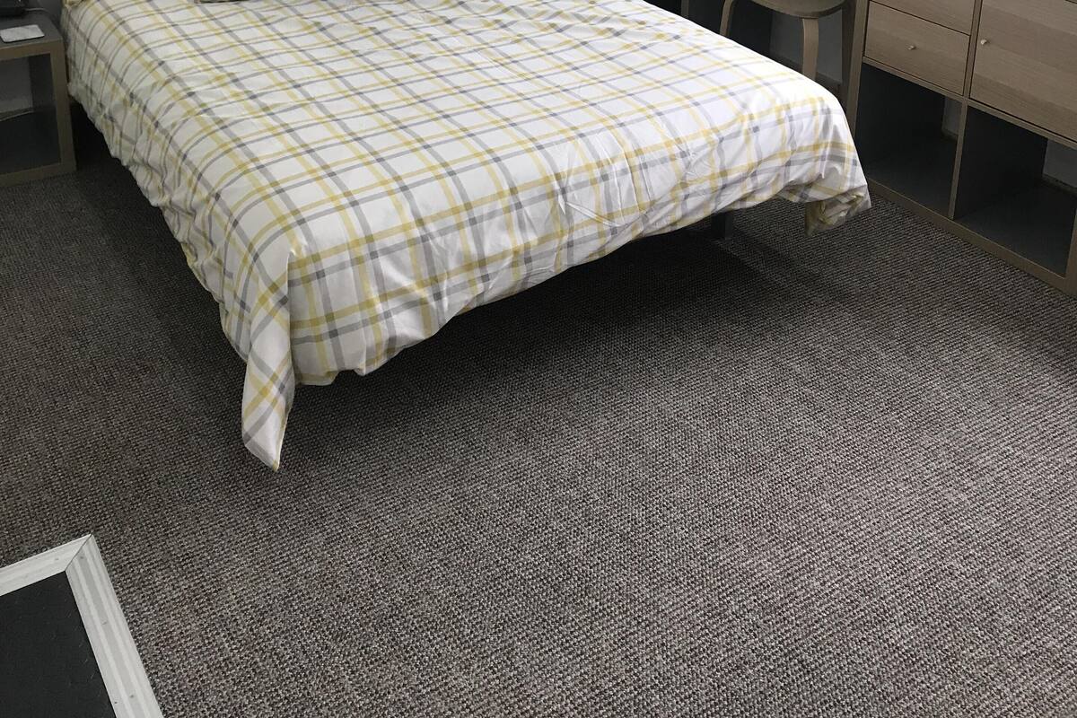 Quarto com cama, escrivaninha, cadeira, luminária e espelho.