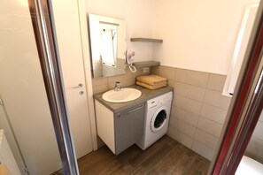 Apartamento Básico, 1 quarto | Comodidades da casa de banho | Um polibã, um secador de cabelo, um bidé, toalhas fornecidas 