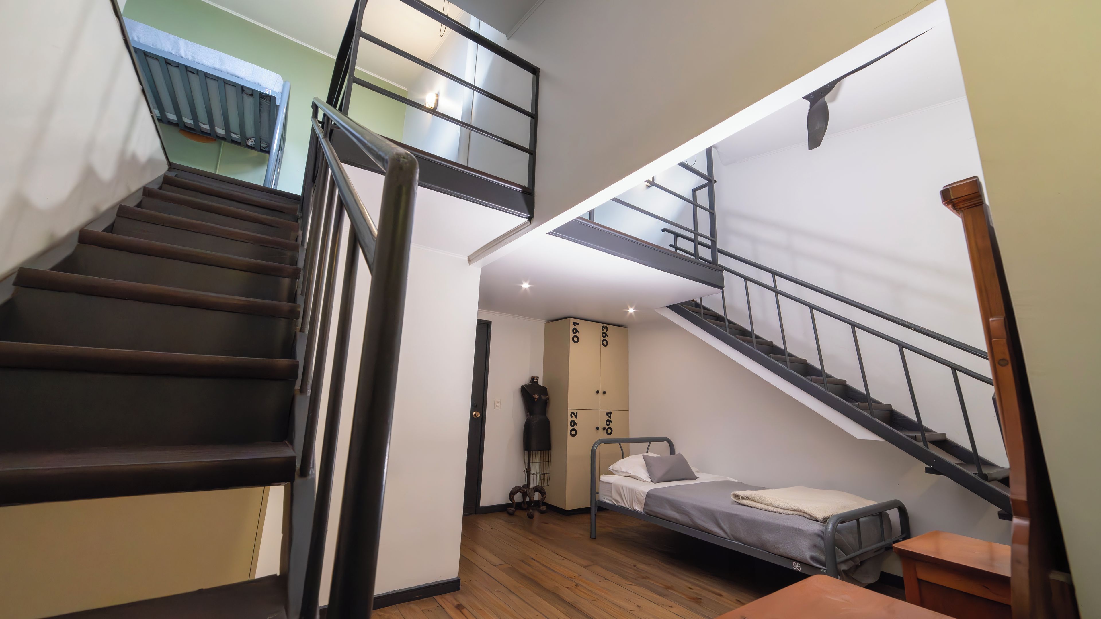 Quarto compacto com beliche, escada e guarda-roupa.