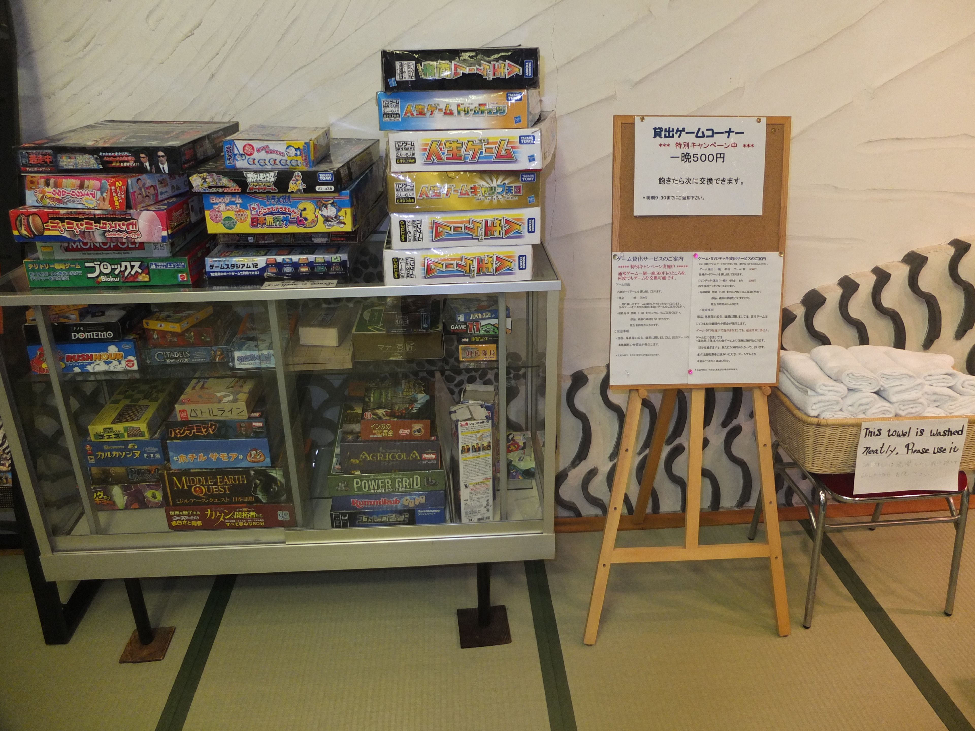 Exposição de jogos de tabuleiro e um letreiro com informações sobre aluguel de jogos.