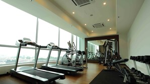 Uma academia com esteiras, elípticos e equipamentos de musculação.