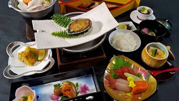 Diversos pratos japoneses, incluindo sushi, sashimi e tigelas de arroz, dispostos sobre uma mesa.