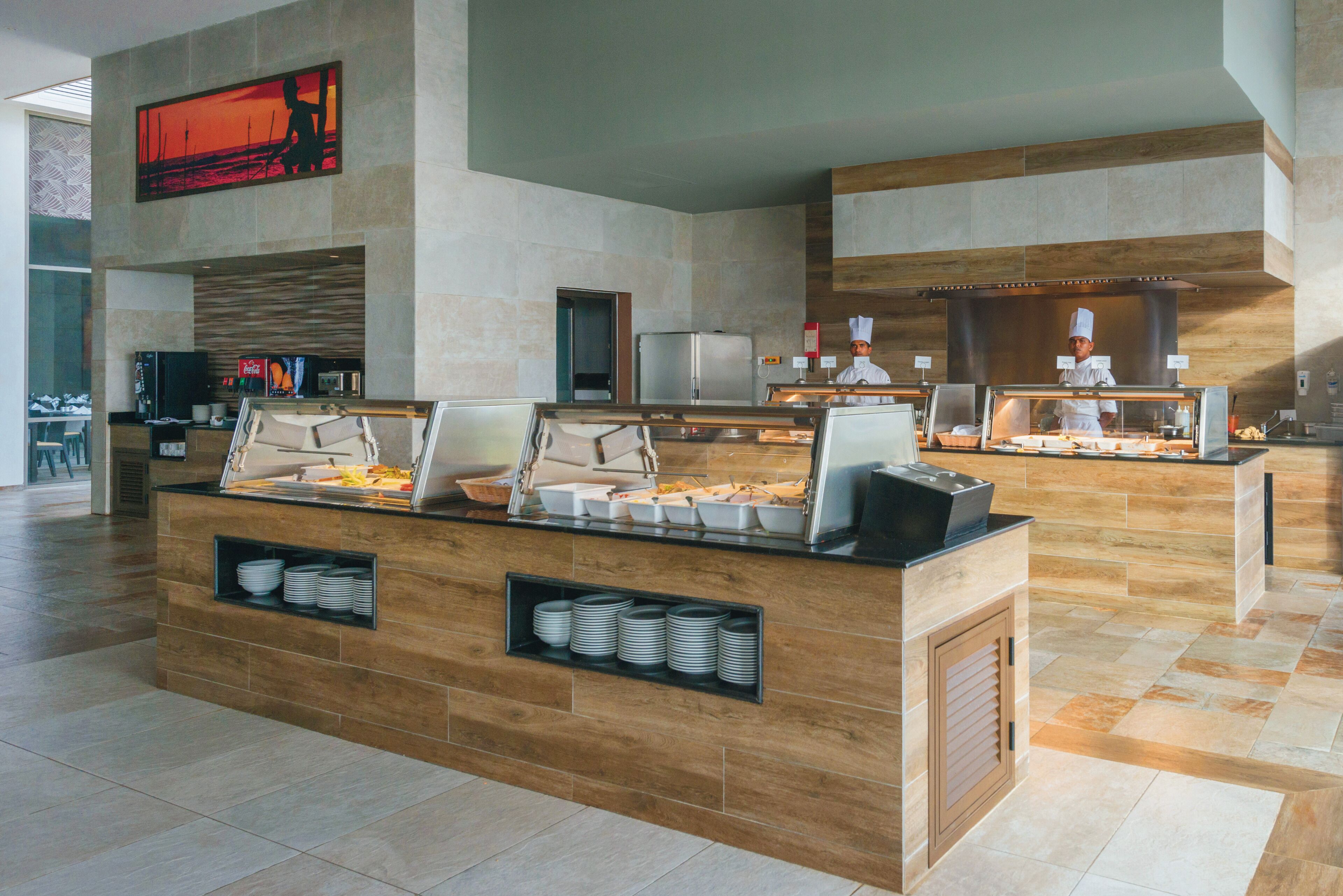 Uma área de buffet com várias estações de serviço, uma grande televisão de tela plana e design de interiores moderno.