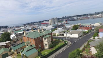 Uma cidade costeira com edifícios industriais, um navio grande e um rio.