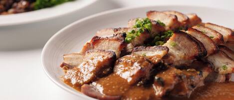Um prato de carne fatiada com molho e decoração.