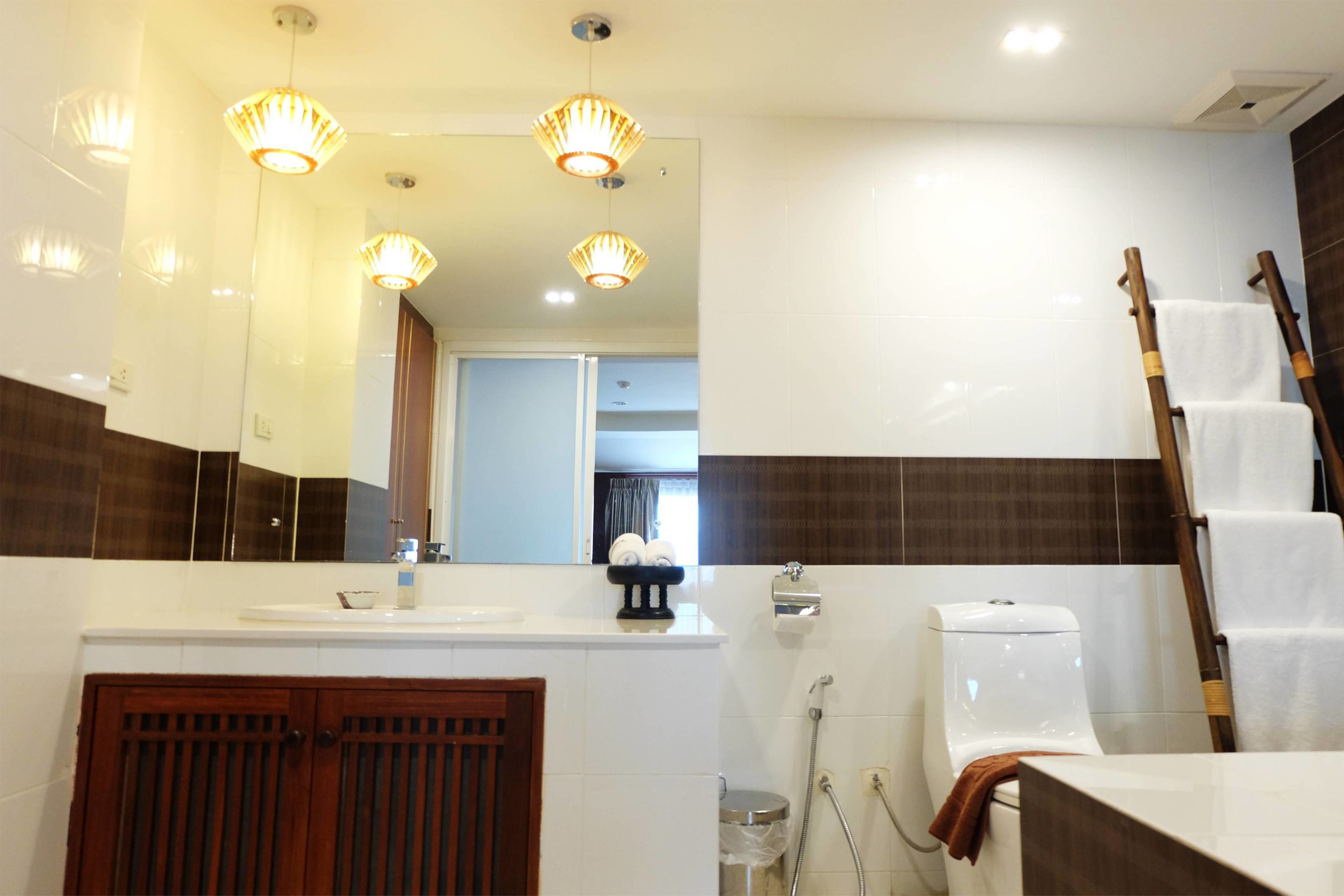 Uma casa de banho moderna com lavatório, espelho e zona de duche.