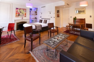 Quarto de hotel moderno com cama, área de estar e lareira.