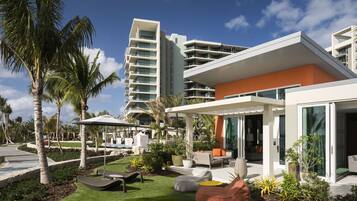 Um hotel moderno com área de piscina, espaço ao ar livre e palmeiras.