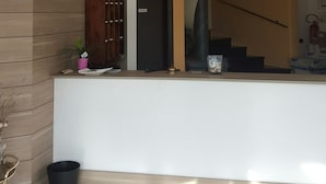 Um interior moderno com um painel de parede de madeira, uma escada e um balcão de recepção.