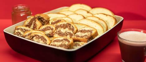 Uma bandeja com fatias de pastelaria e um copo de bebida sobre uma superfície vermelha.