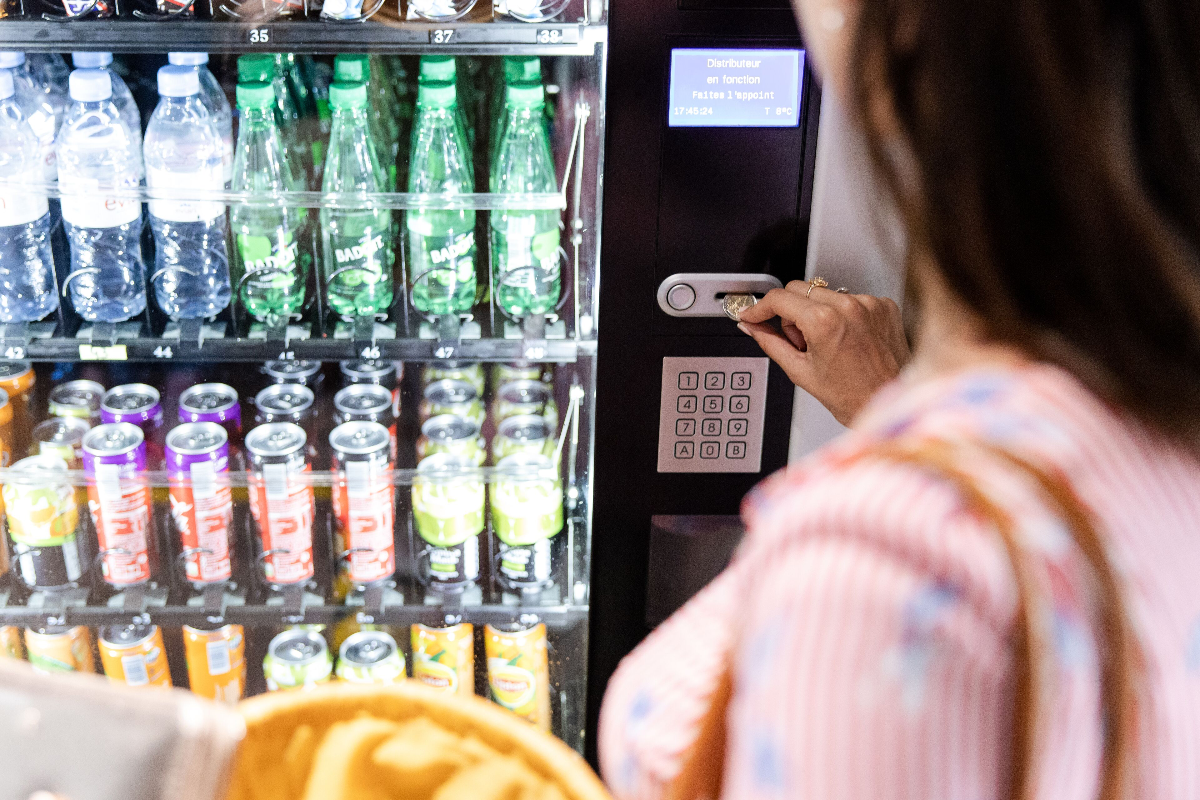 Máquina automática com diversas bebidas e lanches.