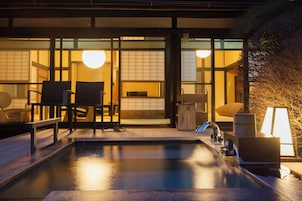 Um edifício em estilo japonês tradicional, com piscina, área de estar e estrutura de madeira.