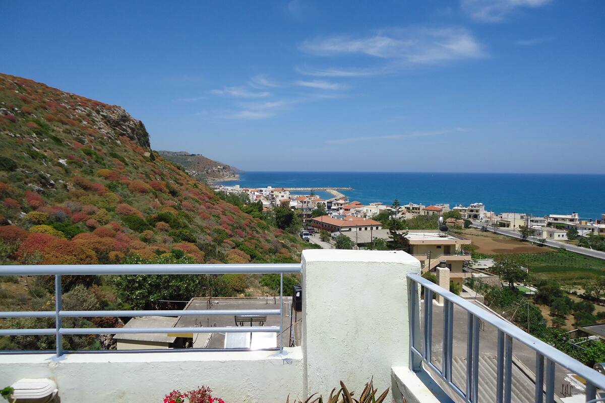 Uma vila costeira com vista para o mar e uma encosta.