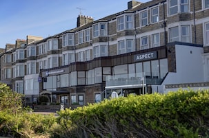 Fileira de casas geminadas com um edifício moderno identificado como 'Best Western Lothersdale' e 'ASPECT'.