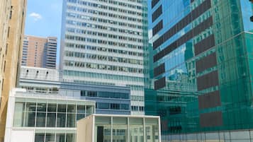 Um edifício moderno com várias janelas de vidro e uma mistura de estilos arquitetônicos, incluindo uma parte com fachada metálica.