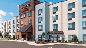 Um hotel TownePlace Suites Marriott com design moderno, vários andares e uma área de estacionamento com vaga para deficientes.