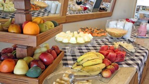Um buffet com diversas frutas e sobremesas.