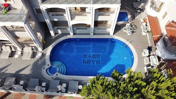 Vista aérea de uma piscina com o nome 'ARYA' escrito na água.