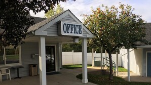 Um pequeno edifício de escritórios com uma placa que diz "OFFICE" sobre a entrada.