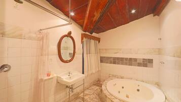 Um banheiro com piso de mármore, pia, banheira e chuveiro com porta de vidro.