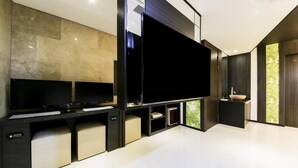 Uma sala de estar moderna com uma televisão de tela grande, sistema de entretenimento integrado e design minimalista.