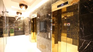 Um elevador moderno com mostrador digital e parede de mármore.