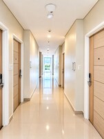 Corredor moderno de hotel, com um caminho reto e longo que leva a um quarto claro e com vista.