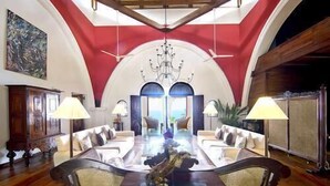 Um quarto espaçoso com uma grande mesa de jantar, várias cadeiras e um candelabro.