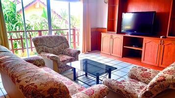 Uma sala de estar com sofá, televisão e armário.