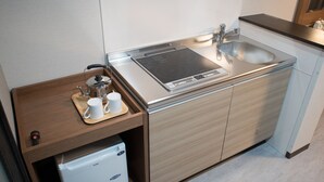 Uma cozinha compacta equipada com fogão, pia e pequeno frigorífico.