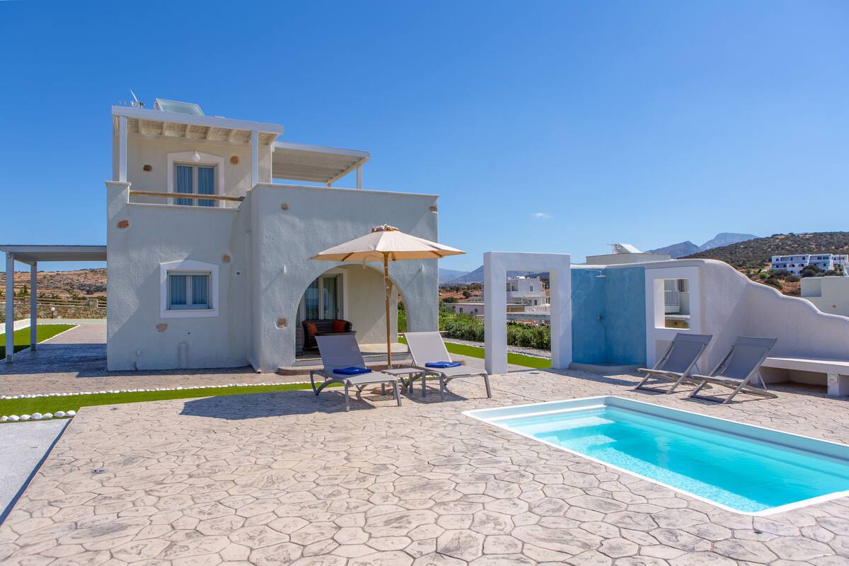 Uma área de piscina com espreguiçadeiras e um pequeno edifício com varanda.