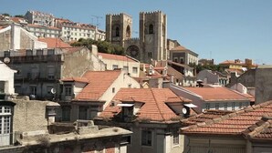 Uma cidade histórica com uma igreja imponente, com duas torres e um grande vitral circular.