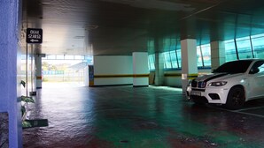 Um estacionamento com um carro branco estacionado em uma vaga.