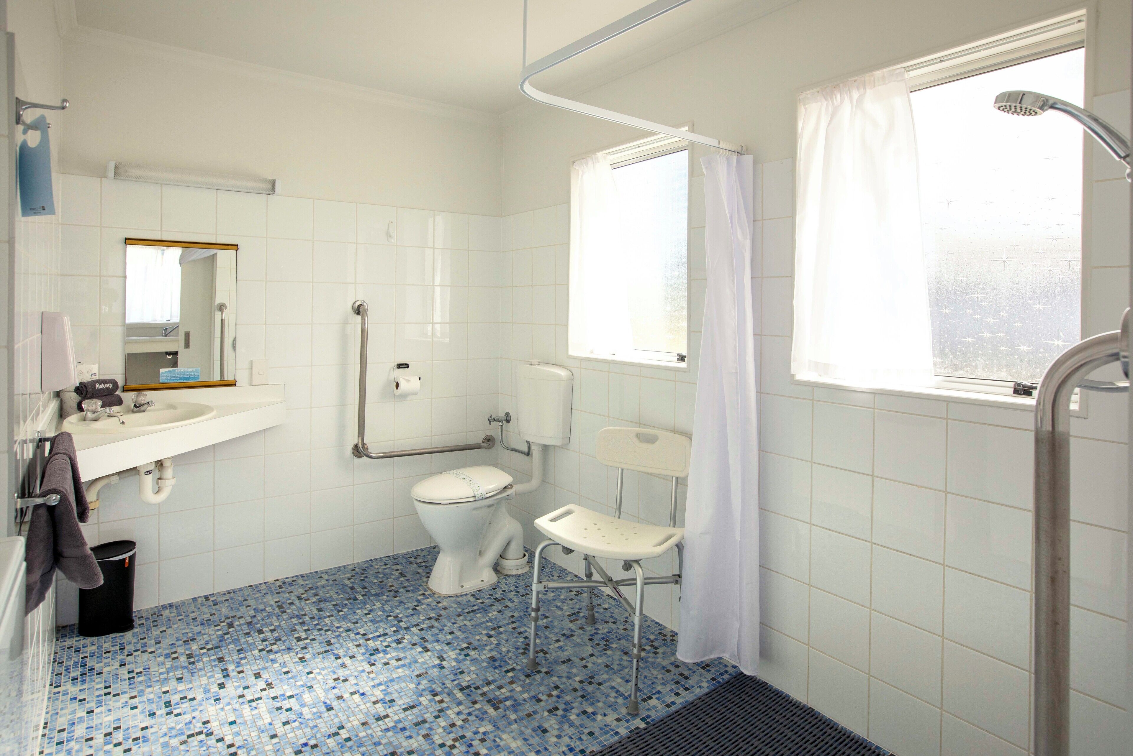 Casa de banho com lavatório branco, sanita e zona de duche.