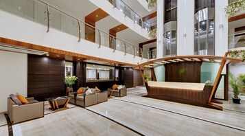 Um hall amplo com um sofá moderno, área de estar e um banco curvo peculiar.