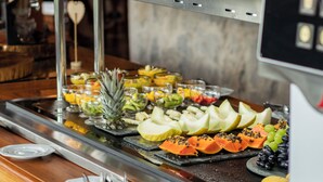 Um buffet com diversas frutas e queijos.