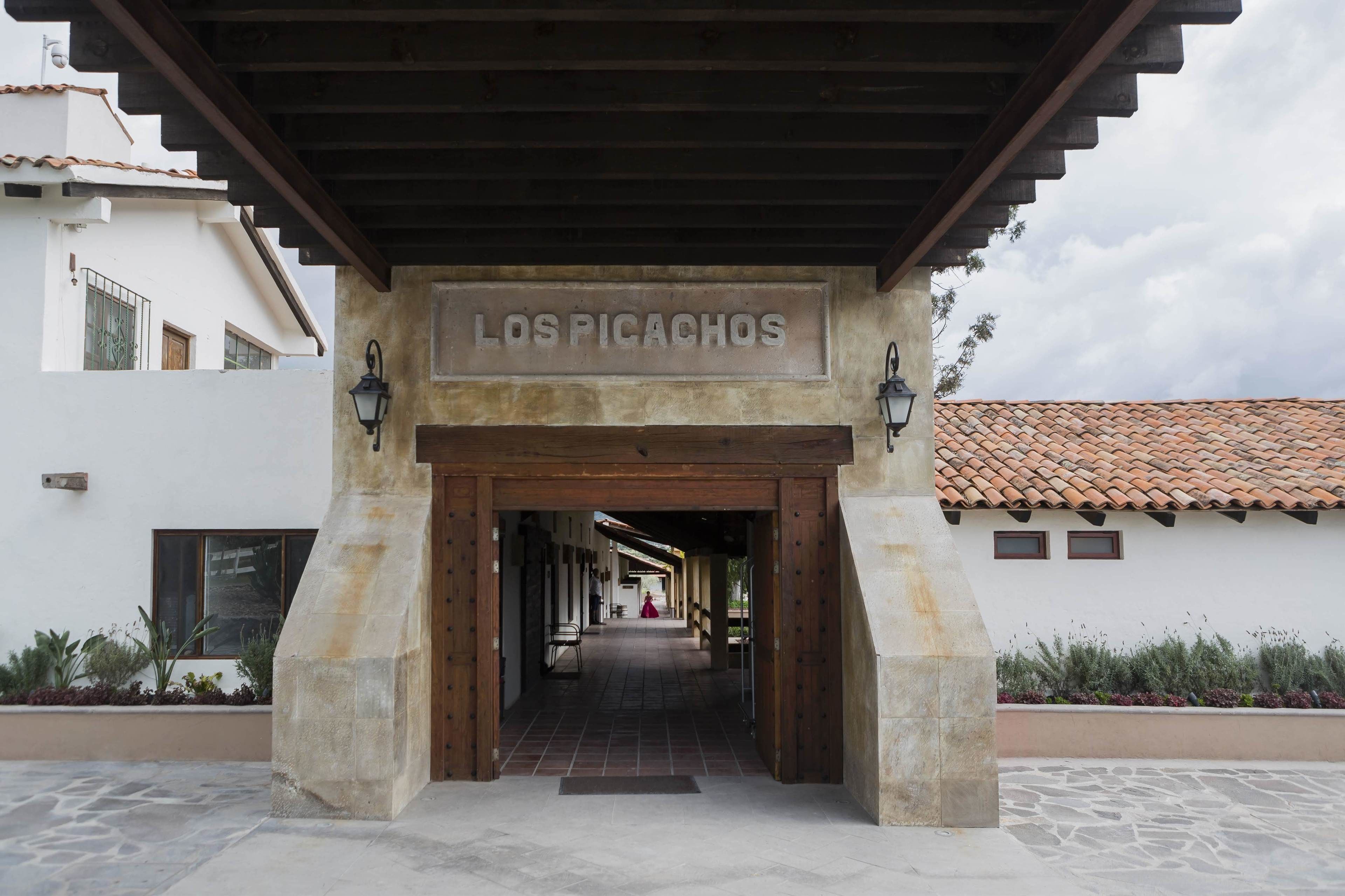 Entrada de um edifício com uma placa que diz 'LOS PICACHOS'.