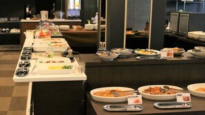 Uma mesa de buffet com diversos pratos e acompanhamentos.