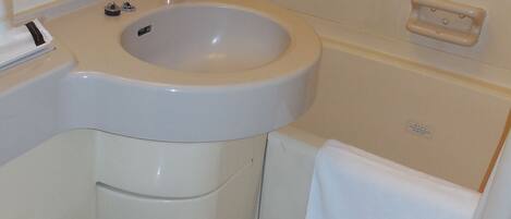 Um banheiro com vaso sanitário, pia e banheira.
