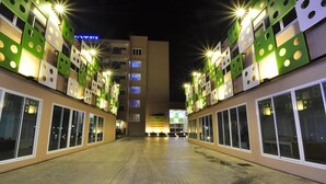 Um hotel com um átrio central, amplas janelas em ambos os lados e um aviso indicando que o restaurante está aberto.