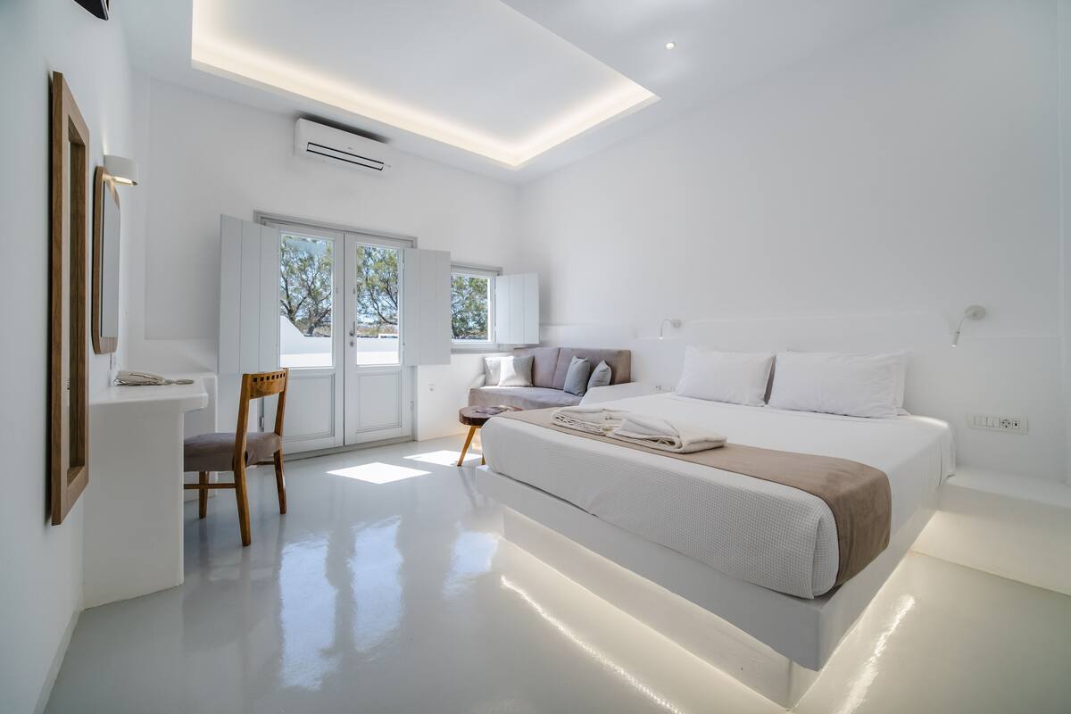 Um quarto moderno com uma cama grande, uma escrivaninha e uma cadeira.