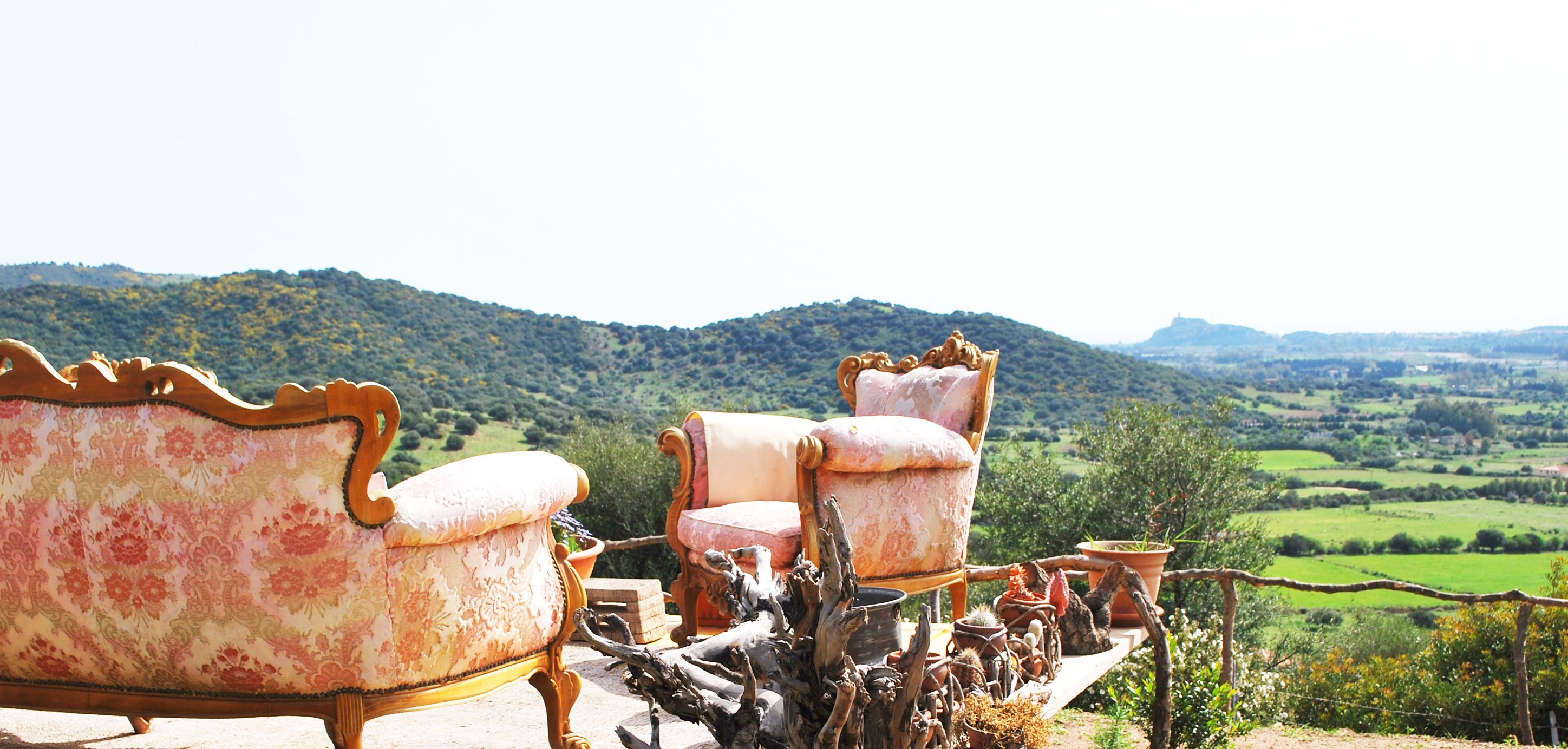 Uma área de estar externa com mobiliário de estilo antigo com vista para uma paisagem deslumbrante.