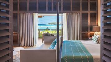 Quarto de hotel com varanda, cama, sofá e mesa.